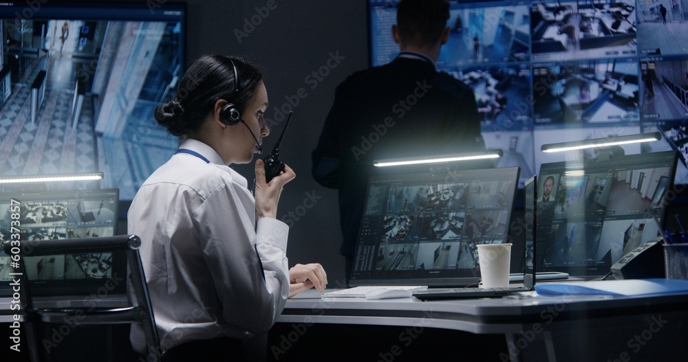 Female security officer works on computer in police monitoring center ...