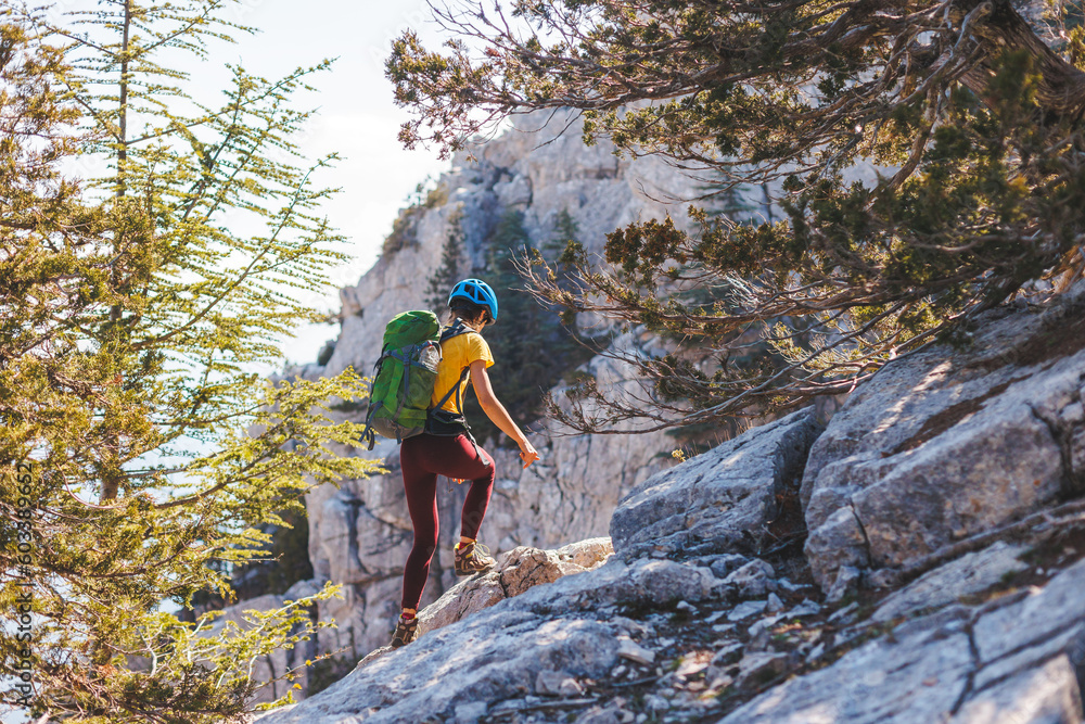 climber with a backpack and a helmet goes along a mountain path in the ...