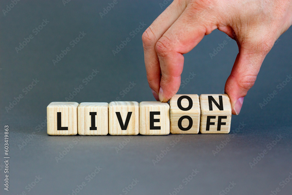 Live on or off symbol. Businessman turns wooden cubes and changes word ...