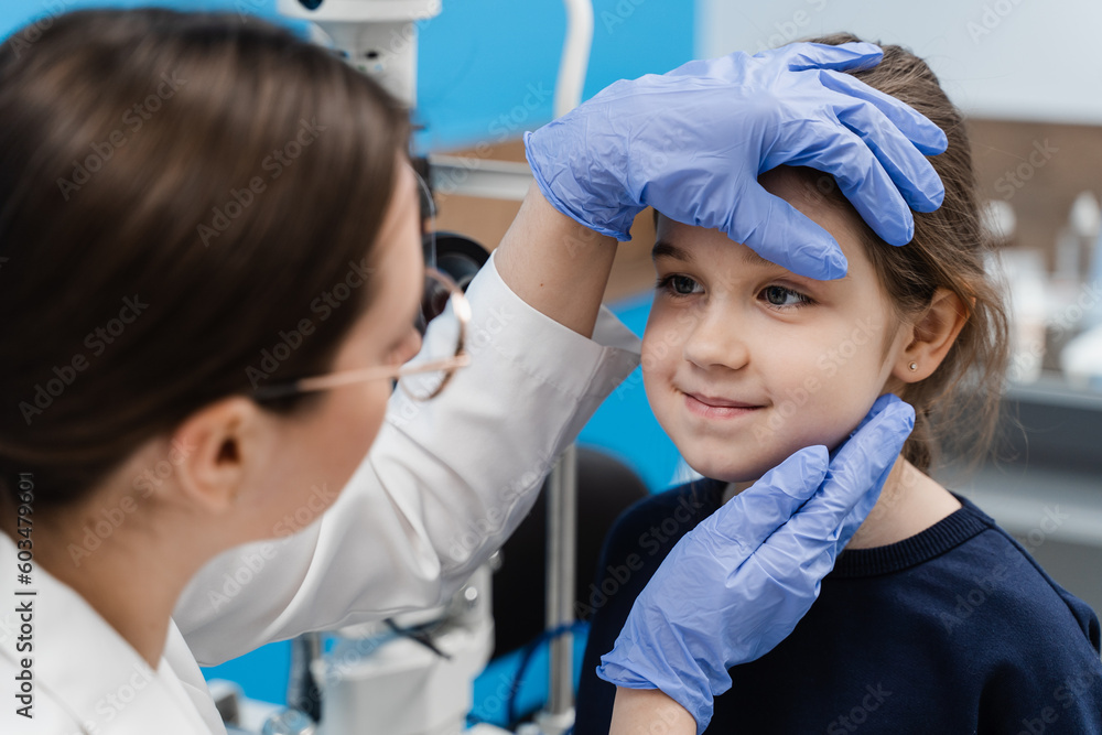 Pediatric ophthalmologist examines eyes and pupil of child ...