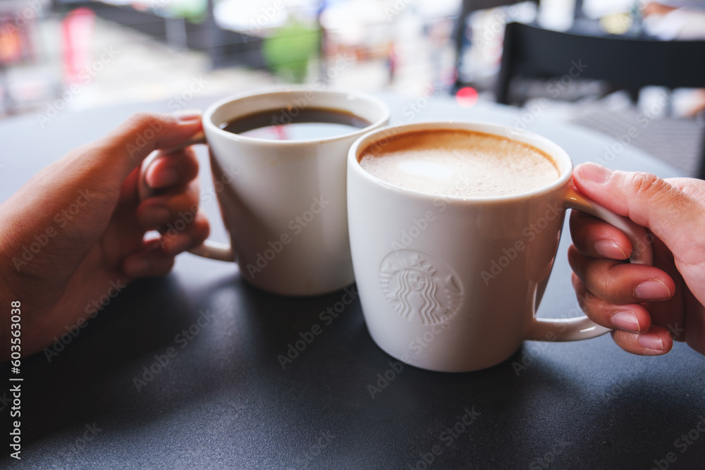 May 15th 2023 : A couple people clinking coffee cups together in ...