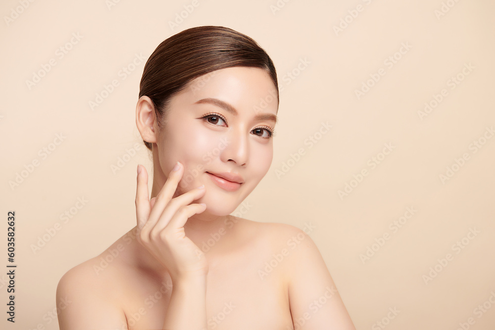 Beautiful young asian woman with clean fresh skin on beige background ...