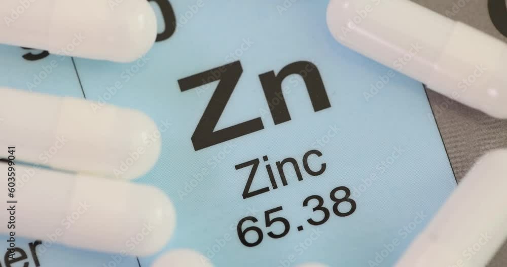 White capsules of zinc lying on blue cardboard with information. Useful ...