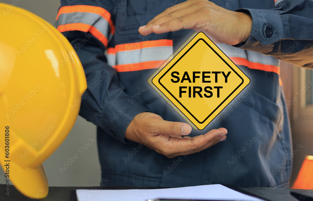 Engineers or supervisors holding a safety first sign to remind ...