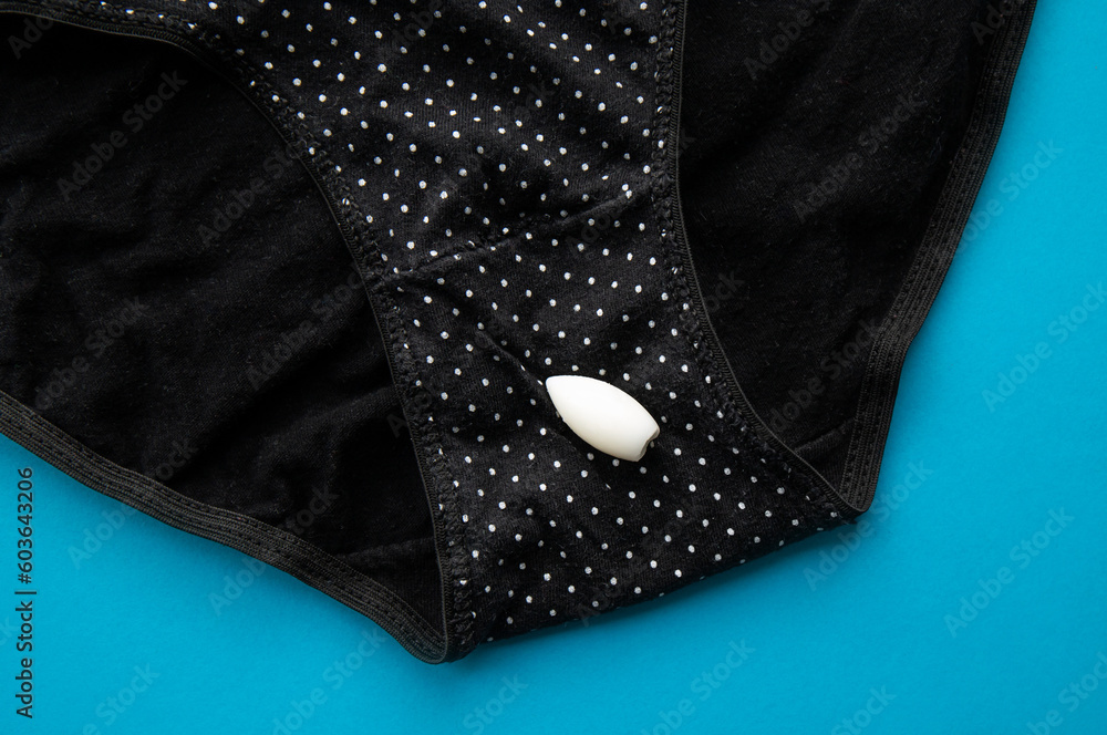 Medicinal bullet shape melting capsule for vaginal use on black dotted ...