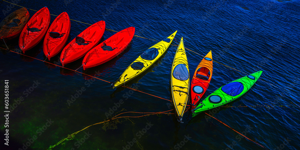 Kayaks on the sea, vibrant colors of yellow, green, red, and blue ...