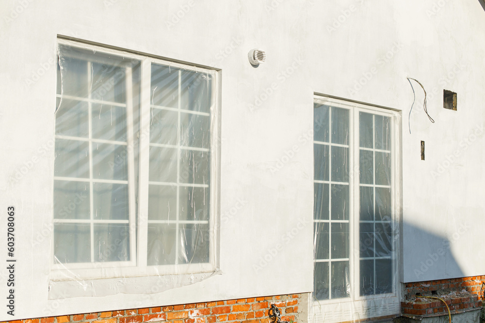 Facade renovation, insulation with mineral wool and white plaster walls ...