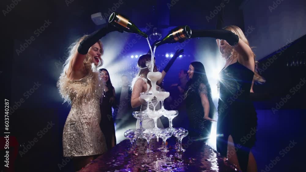 Pyramid of champagne glasses with people dancing at a party. Glasses ...