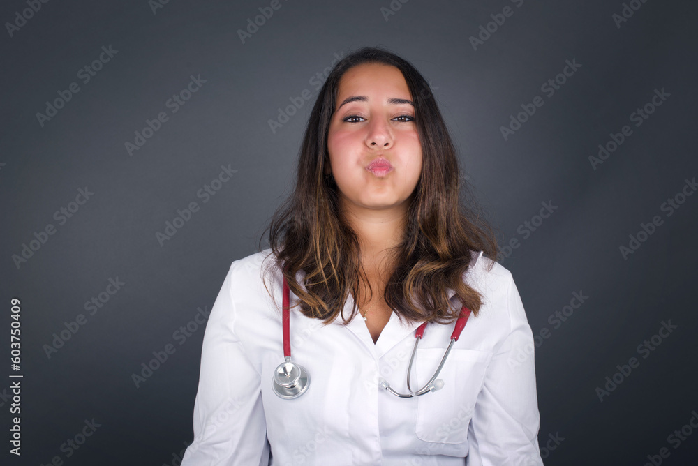 Beautiful young woman puffing cheeks with funny face. Mouth inflated ...
