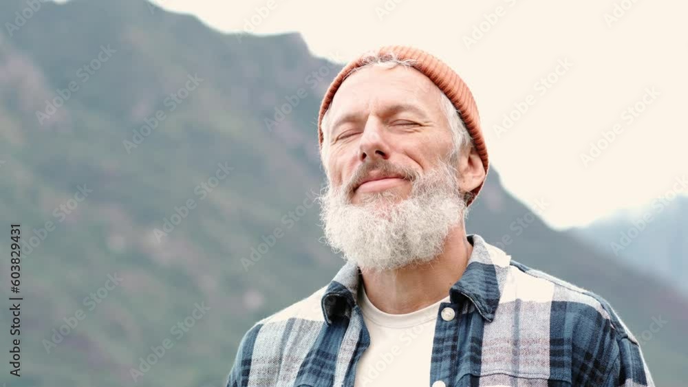 Happy calm older bearded man standing in nature park enjoying. Smiling ...