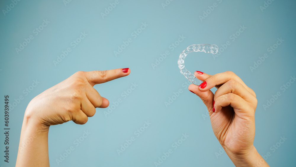 Young Asian Indian woman holding removable invisible aligner, also ...