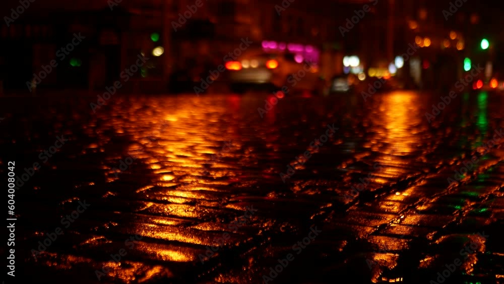 The paving stones became glossy and shiny after a little rain. Cars ...