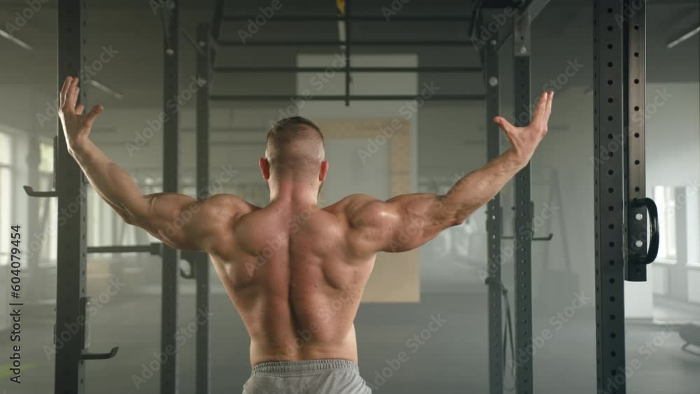 Medium shot back view of bodybuilder showing his muscular back, biceps ...