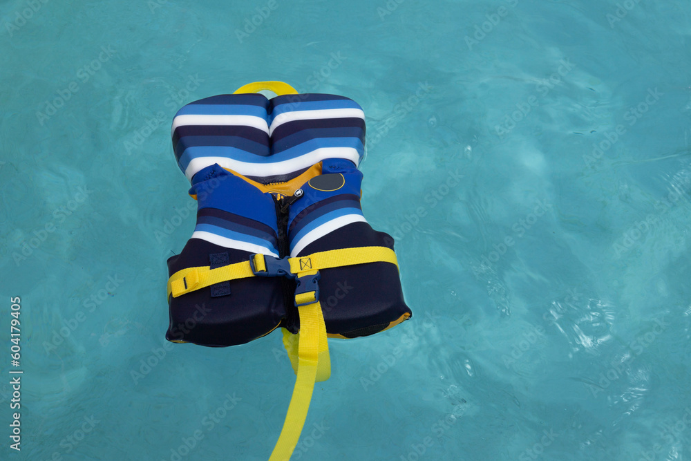 blue and yellow life preserver life vest floating in blue water with no ...