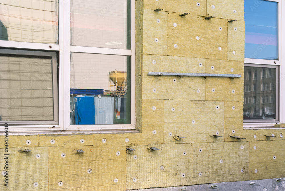 Installation of insulation on the exterior walls of the building. The ...