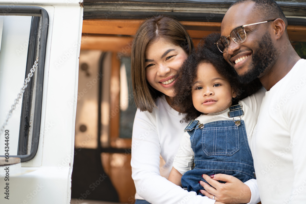Smiling biracial child and family have fun together outdoors. Portrait ...