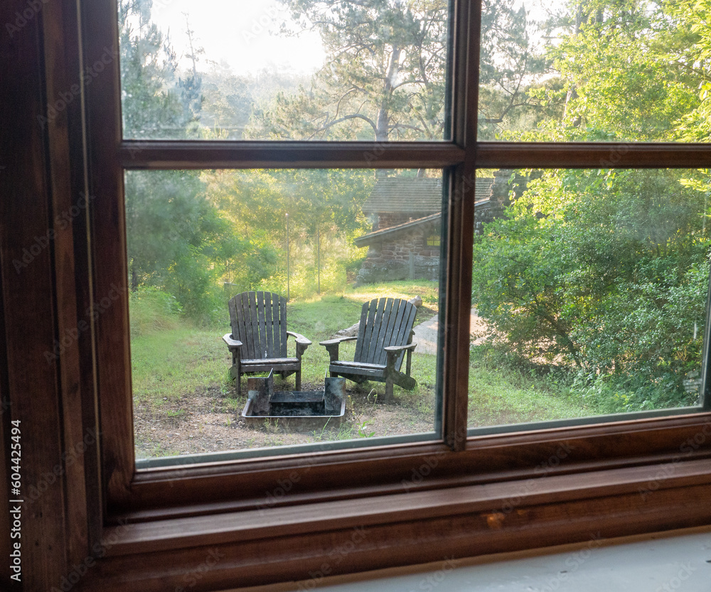 Adirondack chairs and fire pit as seen through a multi-light window in ...