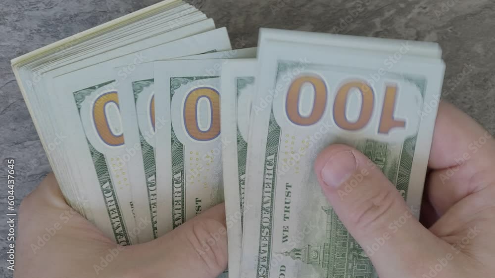 Counting in the hands of 100 US dollar banknotes of the new type ...