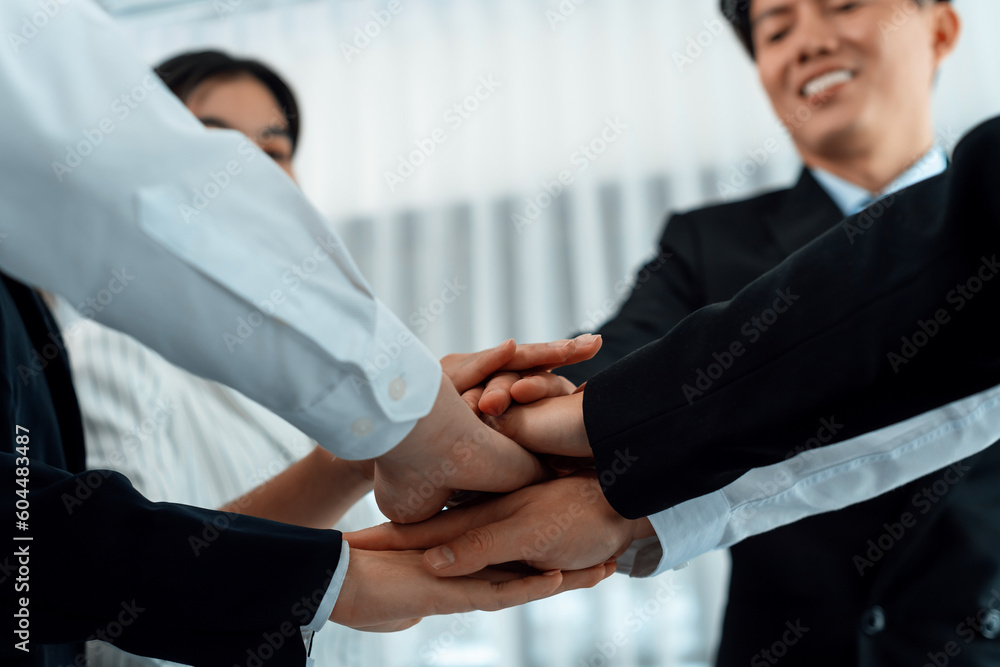 Bottom view partial hands wearing formal suit joining stack as symbol ...