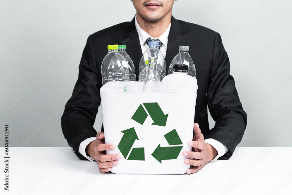 Businessman hold recycle bin filled with plastic bottle on isolated ...