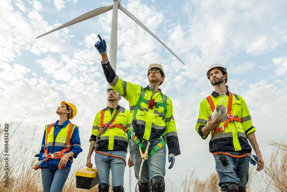 Teamwork engineer worker wearing safety uniform discuss operational planning at wind turbine ...