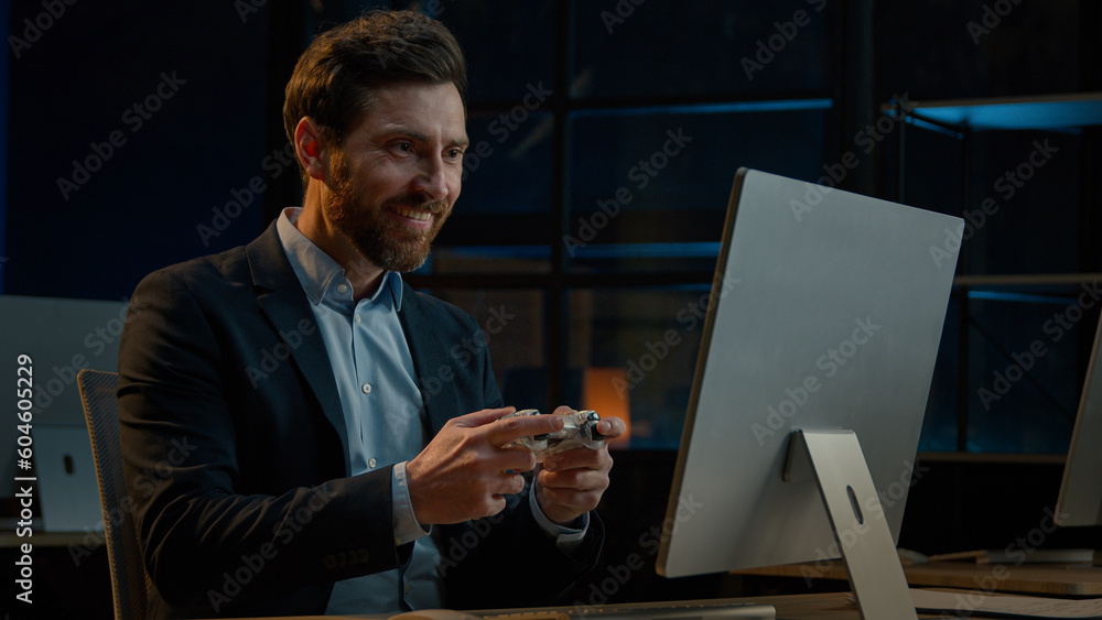 Adult businessman employee working in evening office happy male gamer ...