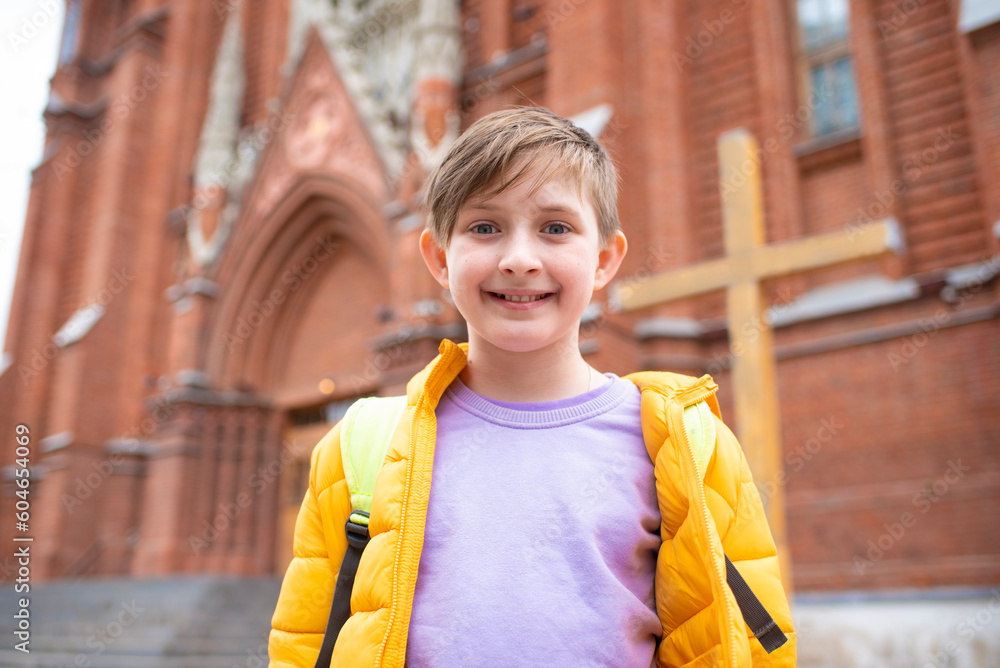smiling happy child in goes to Sunday school in the temple, stands in ...