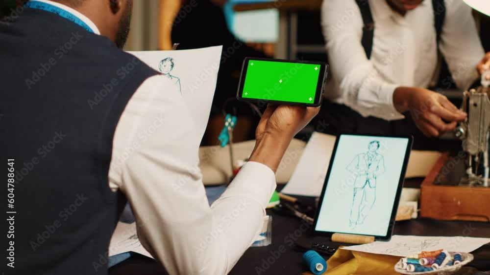 Craftsman using greenscreen in workshop with designers, looking at ...