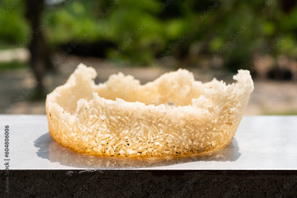 The rice crust is dried in the sun before being processed into ...