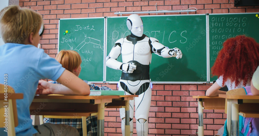 Automatic human-like robot standing in front of class with pupils and ...