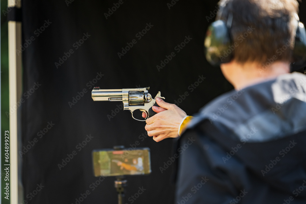 Shooting from a revolver in a shooting range outdoors. Stock Photo ...