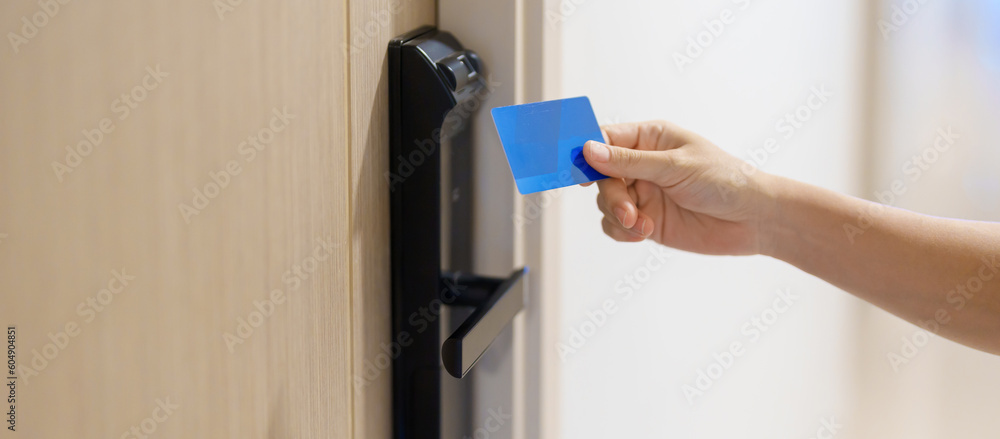 Hand using keycard for smart digital door lock while open or close the door at home or apartment ...