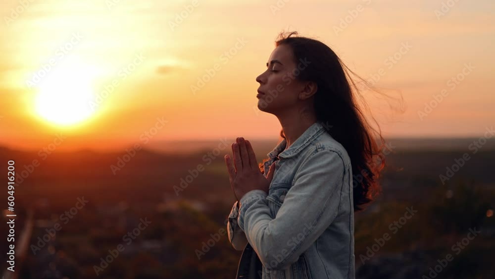 Girl folded hands in prayer silhouette at sunset. woman praying ...