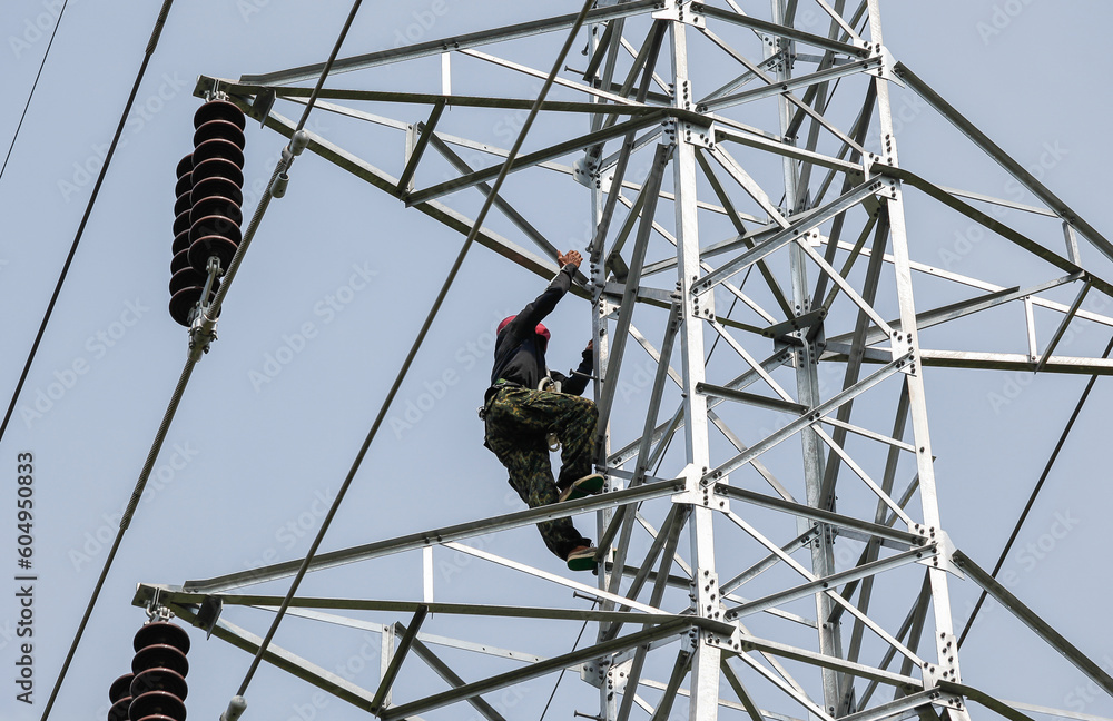 lineman climbing on electrical transmission line tower Stock Photo ...