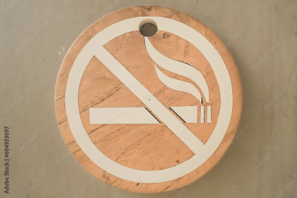 Round don't smoke sign. Wooden no smoking signage with gray walls ...