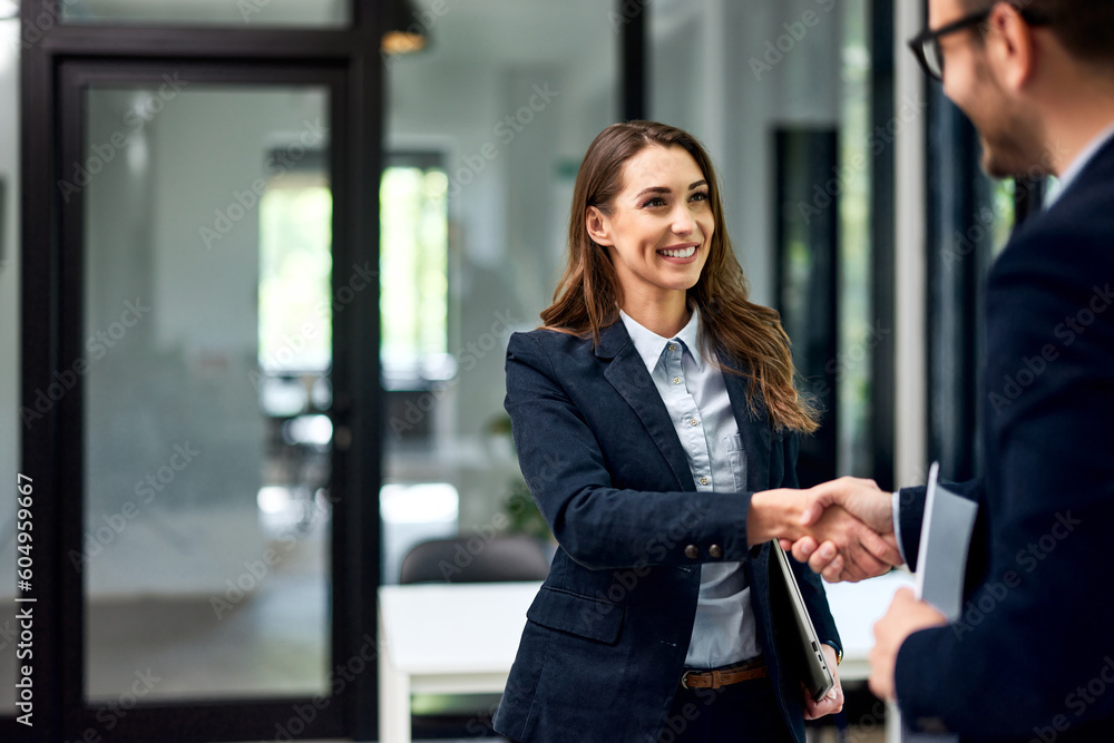 A smiling female employee handshake with a male boss at the office ...