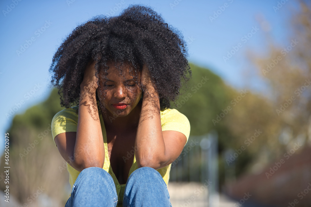 Portrait of a young, beautiful black woman with afro hair, wearing a ...