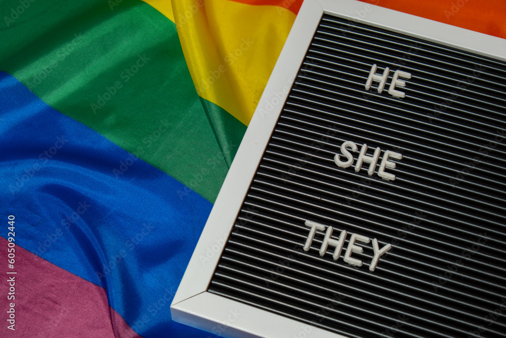 Foto Stock HE SHE THEY text Neo pronouns concept on Rainbow flag ...