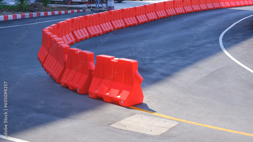 Row of orange plastic barriers on curve asphalt road in outdoor car ...