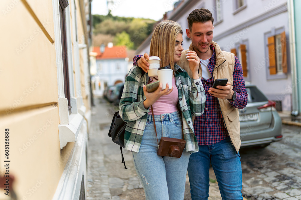 tourists walk around the city hugging each other, drinking coffee to go ...
