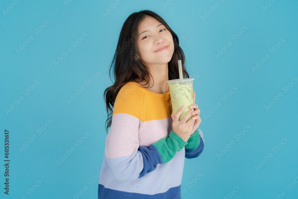 Beautiful young woman smiling happily while holding bubble tea in her ...
