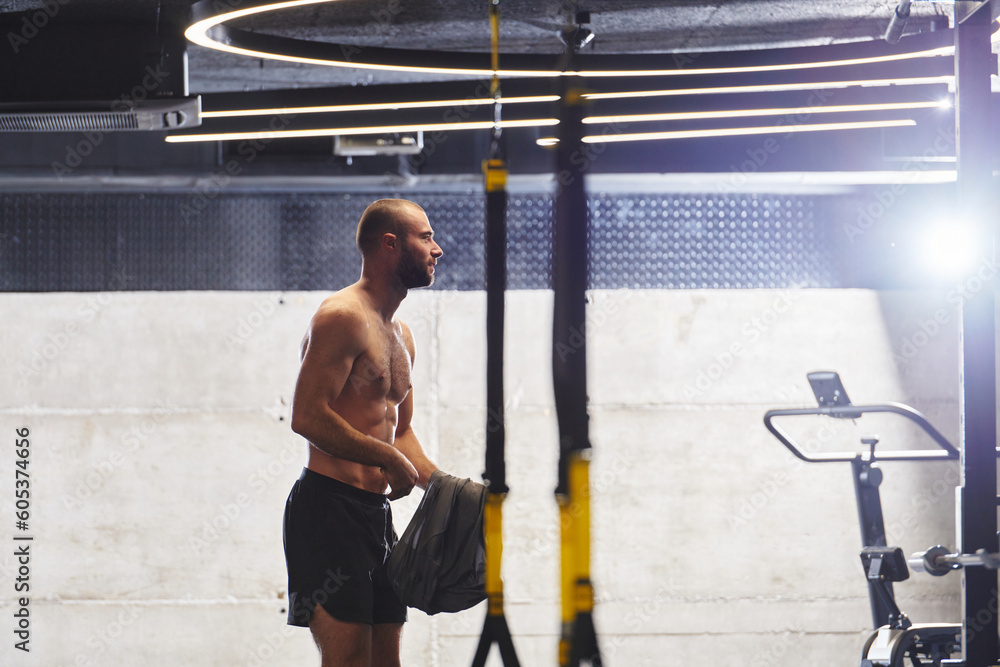 A muscular man in the gym, preparing for his workout, exudes ...