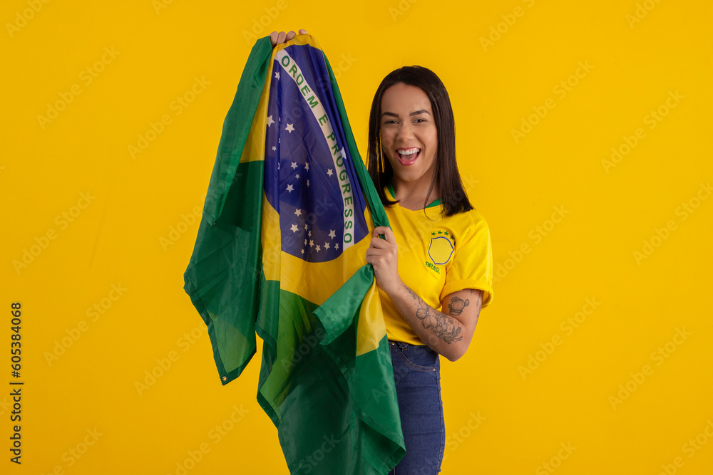 Young beautiful woman wearing yellow shirt and holding Brazil flag in ...