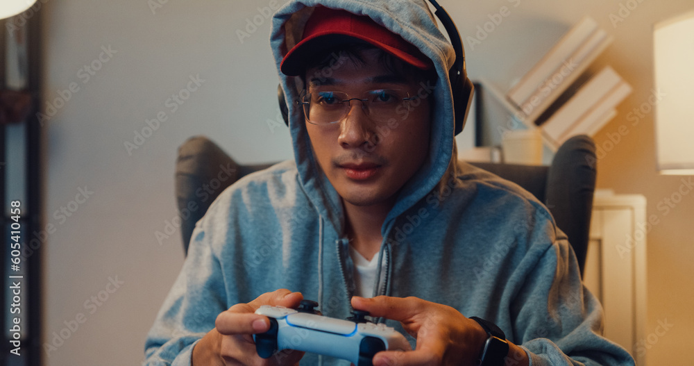Young Asian man gamer wear gray hoodie red cap and headphone hold ...