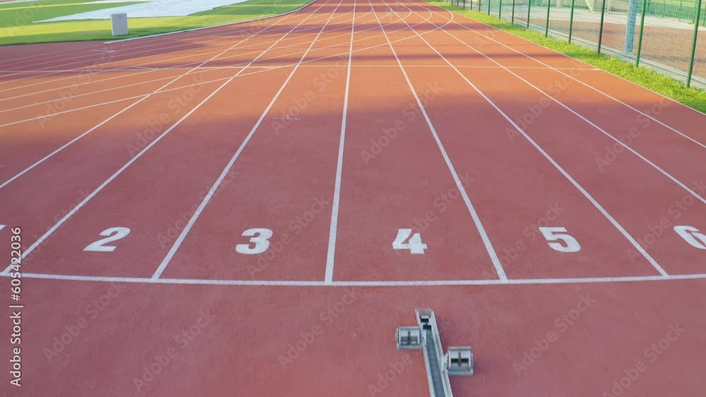 Starting block and starting line of the red tartan athletic track with ...