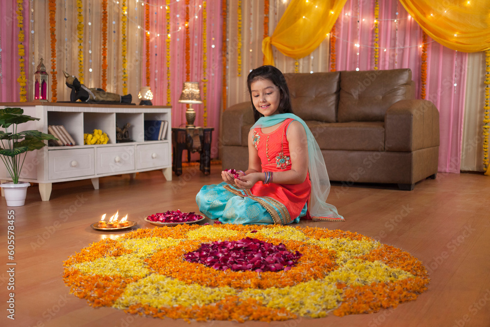 Cute Indian girl making beautiful rangoli using flowers petals ...