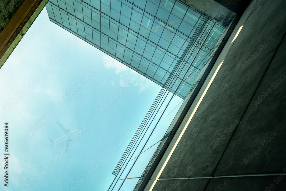 Bottom up view of modern sustainable glass office building and airplane ...