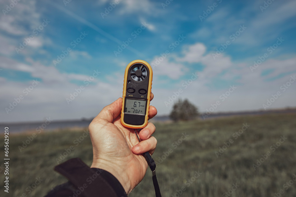 Person holding modern digital anemometer outdoors for measuring wind ...