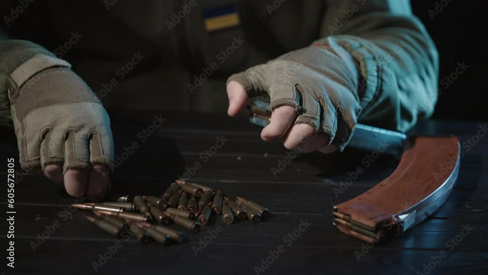 The male hands of a Ukrainian military man load a kalashnikov assault ...