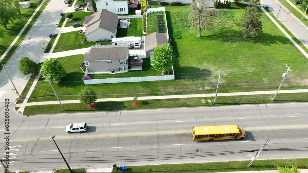 School bus driving down a residential street with school painted on the ...
